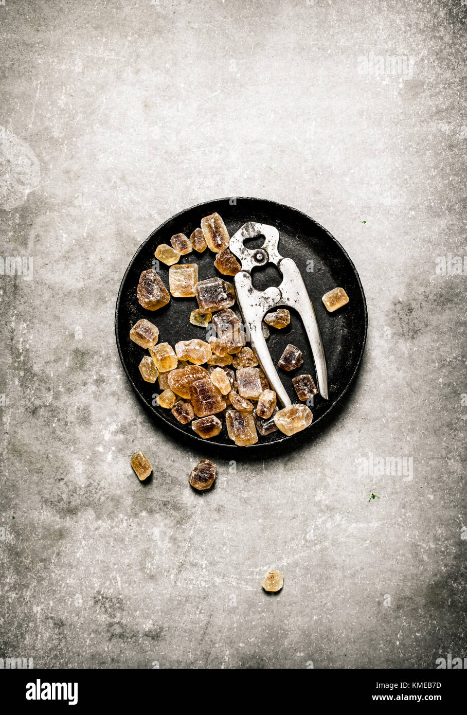 Dark crystalline sugar with wire cutters . On a stone background Stock ...