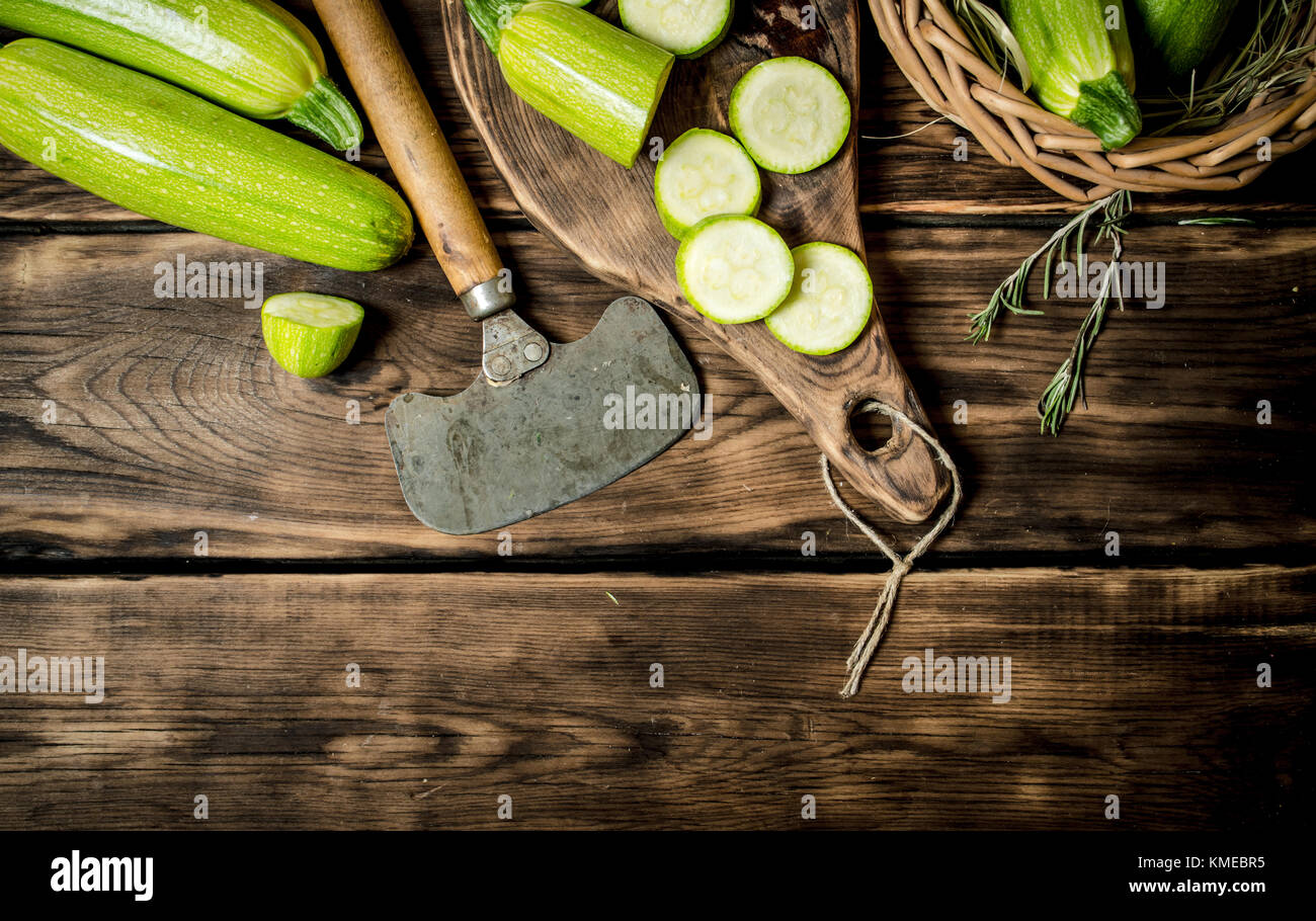 Zucchini with a knife for cutting . On wooden background Stock Photo ...