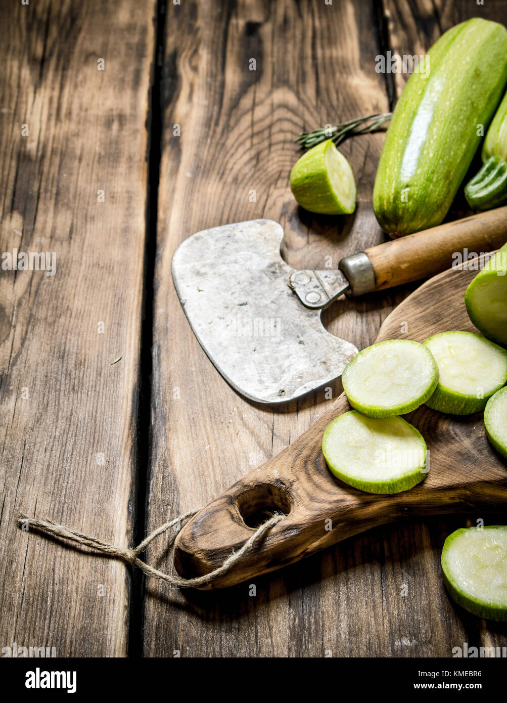 Zucchini with a knife for cutting . On wooden background Stock Photo ...