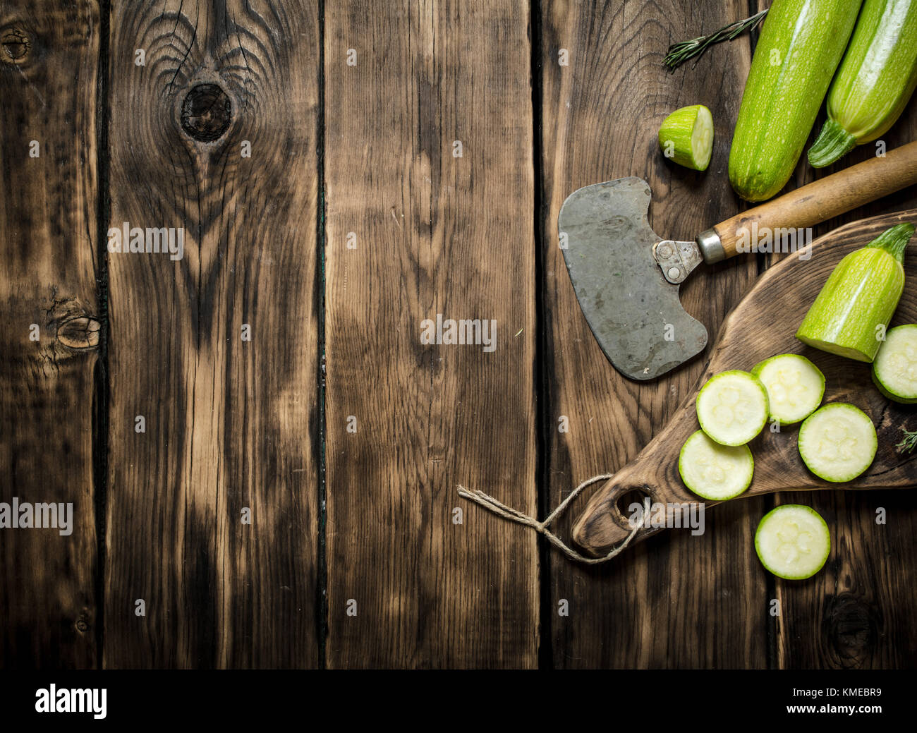 Zucchini with a knife for cutting . On wooden background Stock Photo ...