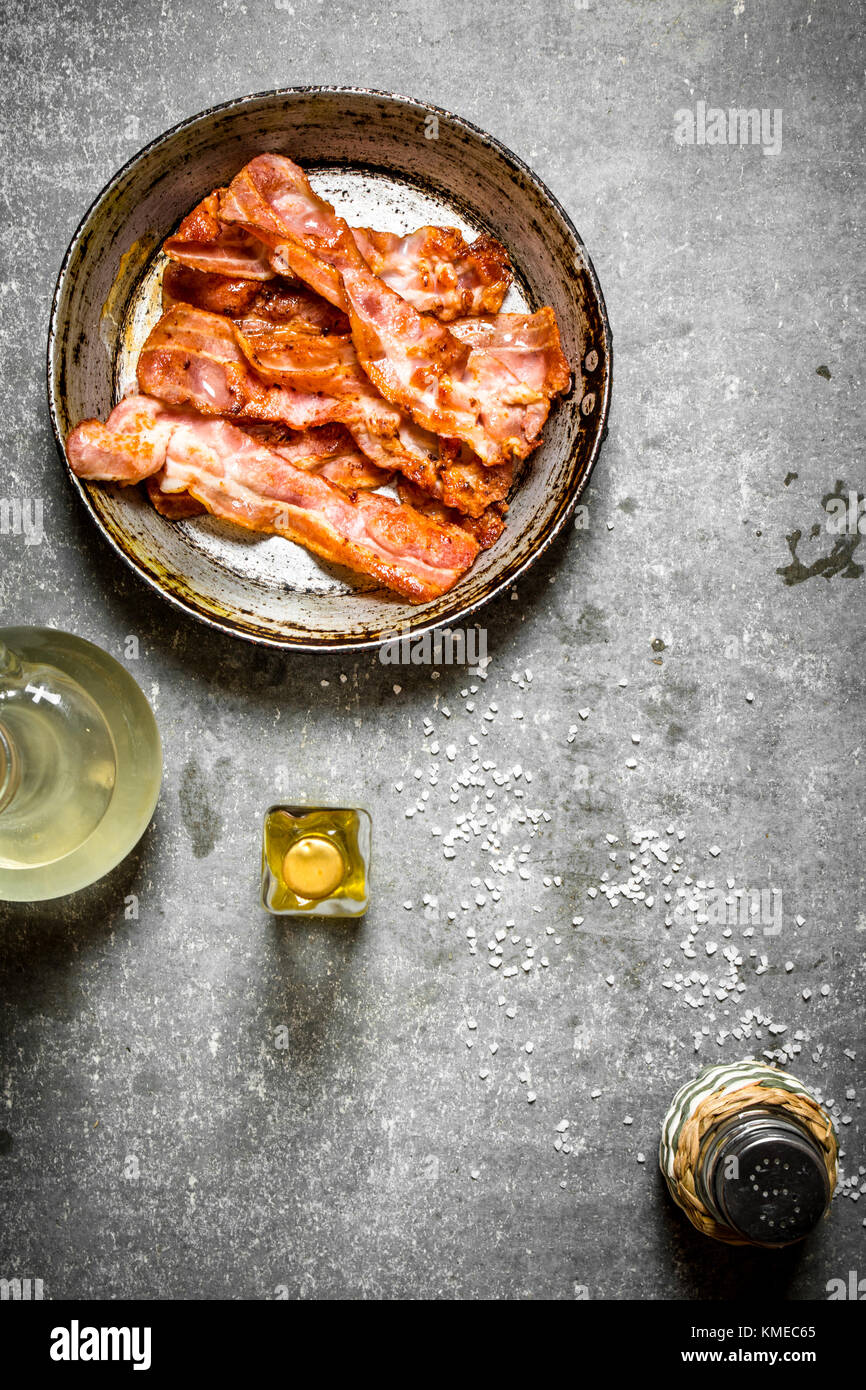 Fried bacon with oil and salt. On a stone background Stock Photo - Alamy