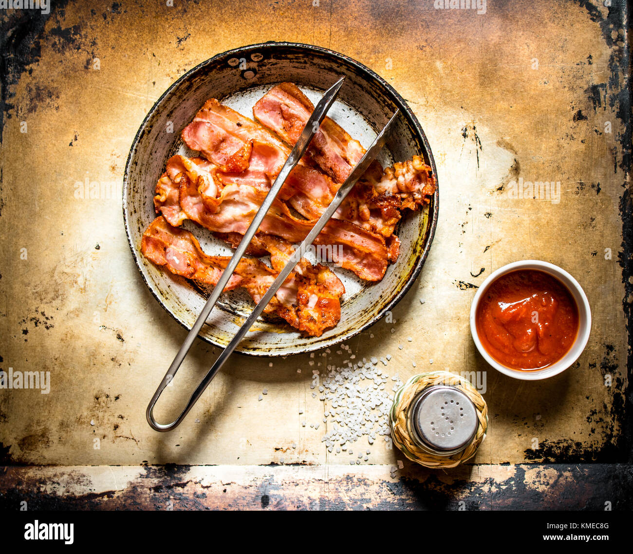 Fried bacon with sauce and salt. On an old rustic background Stock ...