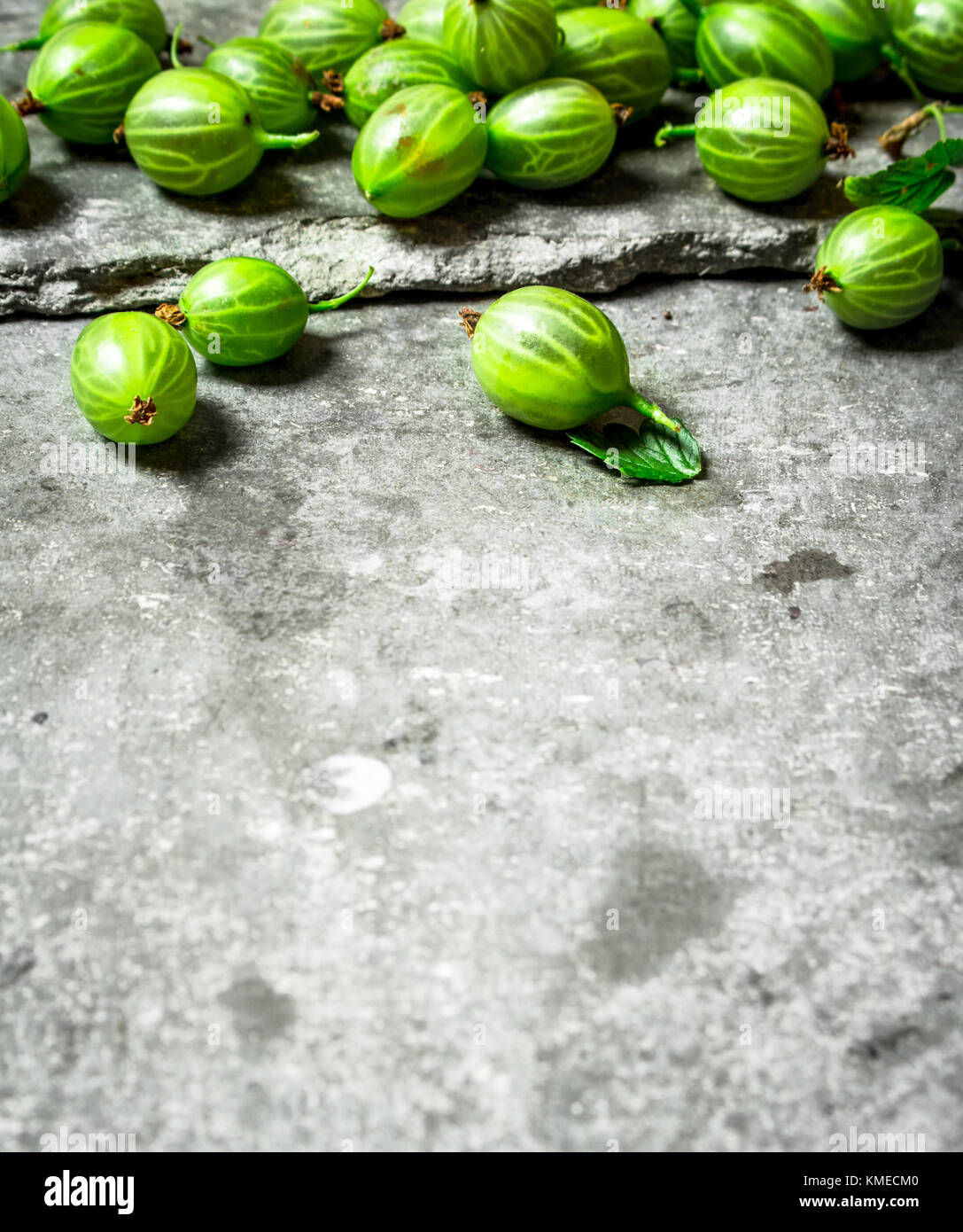 Fresh gooseberries with leaves. On the stone table Stock Photo - Alamy