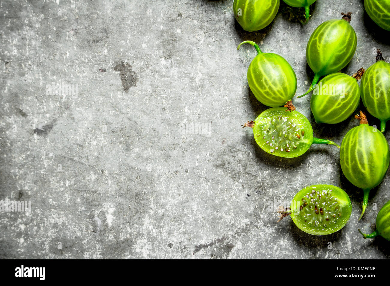 Fresh green gooseberries . On a stone background Stock Photo - Alamy