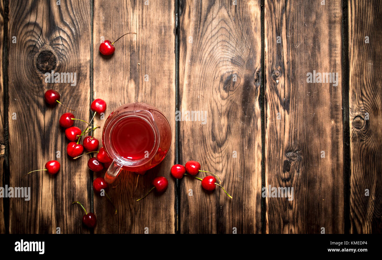 Fresh cherry juice in the pitcher. On wooden background Stock Photo - Alamy