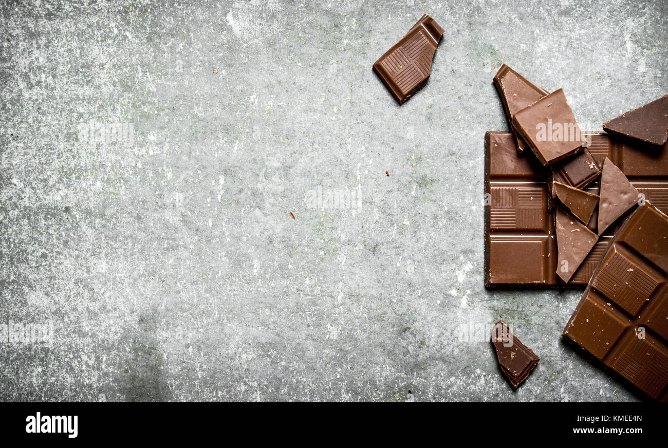 Broken chocolate bar. On the stone table Stock Photo - Alamy