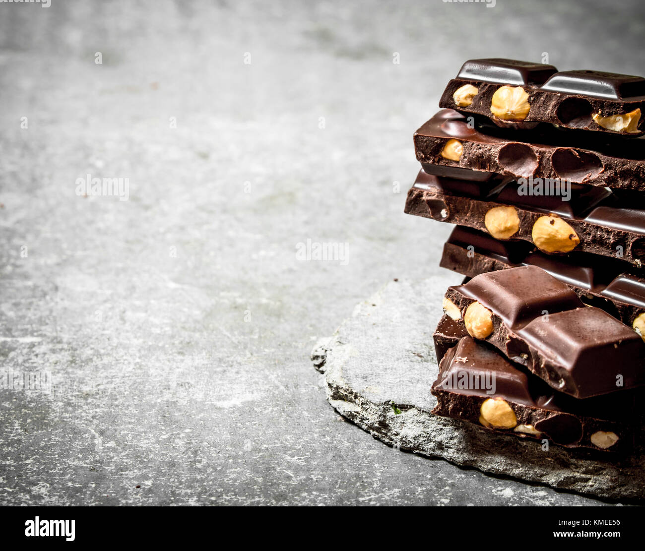 Chocolate with whole hazelnuts. On the stone table Stock Photo - Alamy