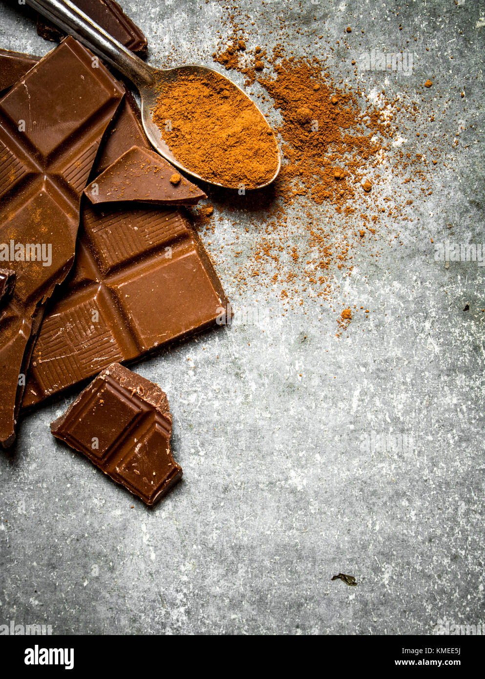 Chocolate with cocoa powder in the spoon. On the stone table Stock ...