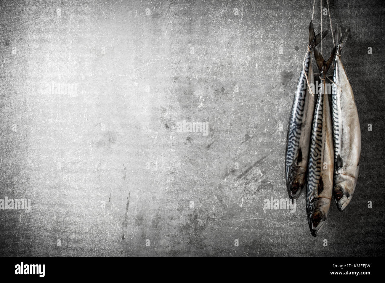 Raw fish hanging on a rope. On a stone background Stock Photo - Alamy