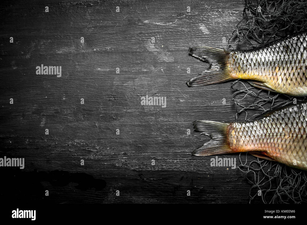Fish with a fishing net. On a black wooden background Stock Photo - Alamy