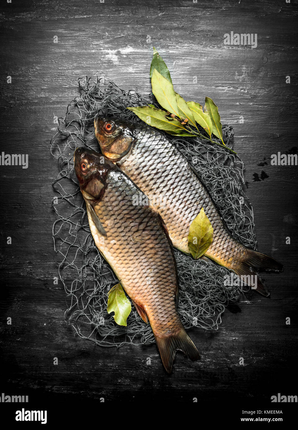 Fish with a fishing net. On a black wooden background Stock Photo - Alamy