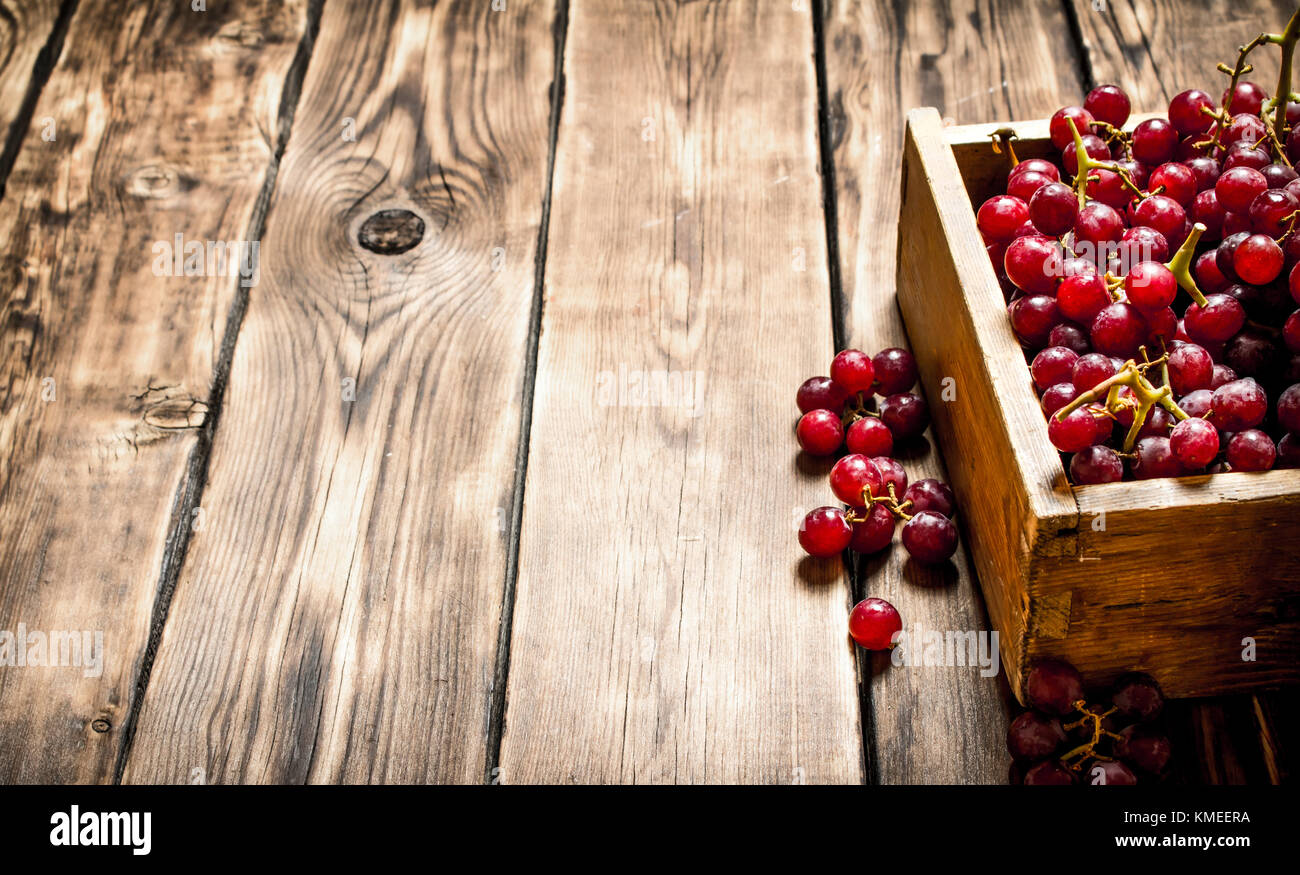 Red grapes in an old box. On wooden background Stock Photo - Alamy