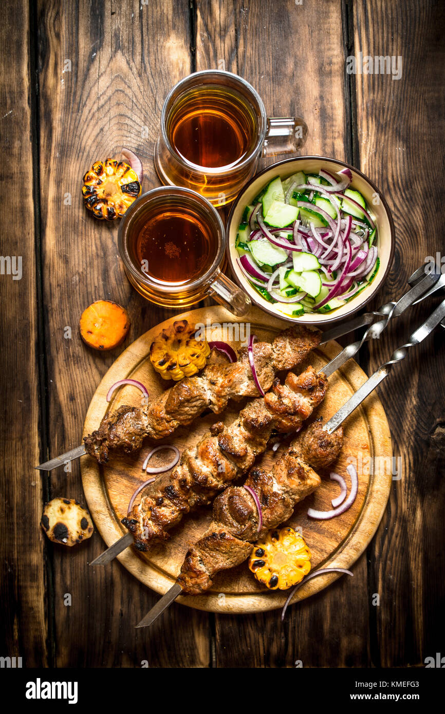 Pork kebab with beer and vegetables. On wooden background Stock Photo ...