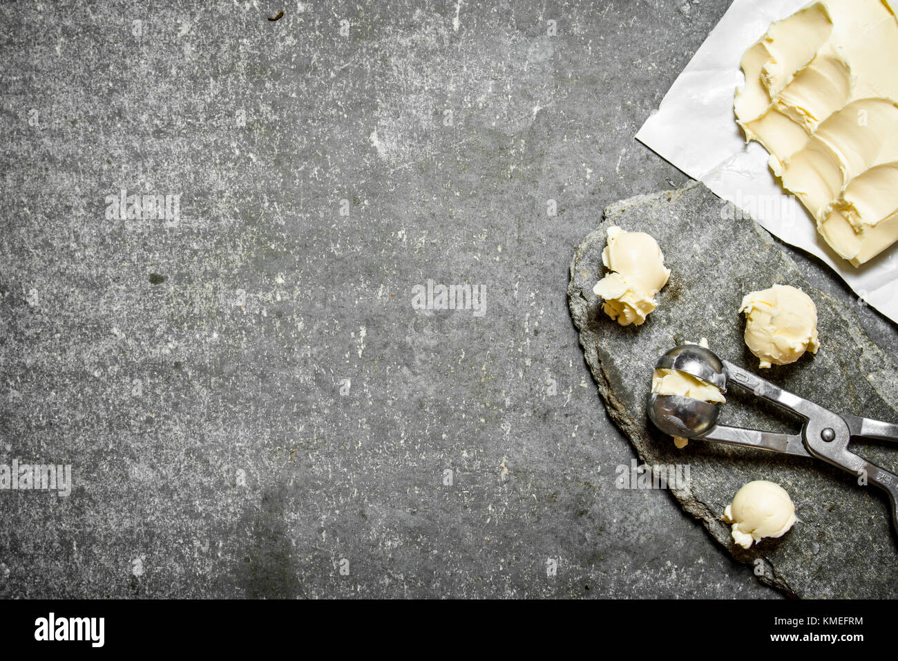 Balls of butter with a measuring scissors. On the stone table Stock ...