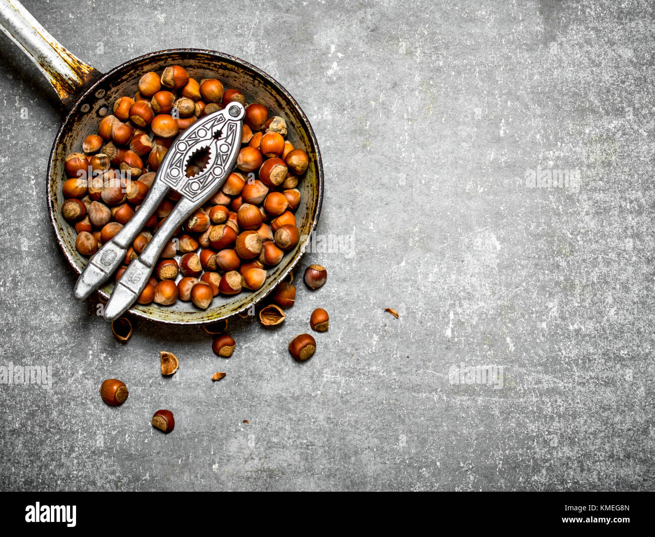 Hazelnuts and a Nutcracker in the old pan. On the stone table Stock ...