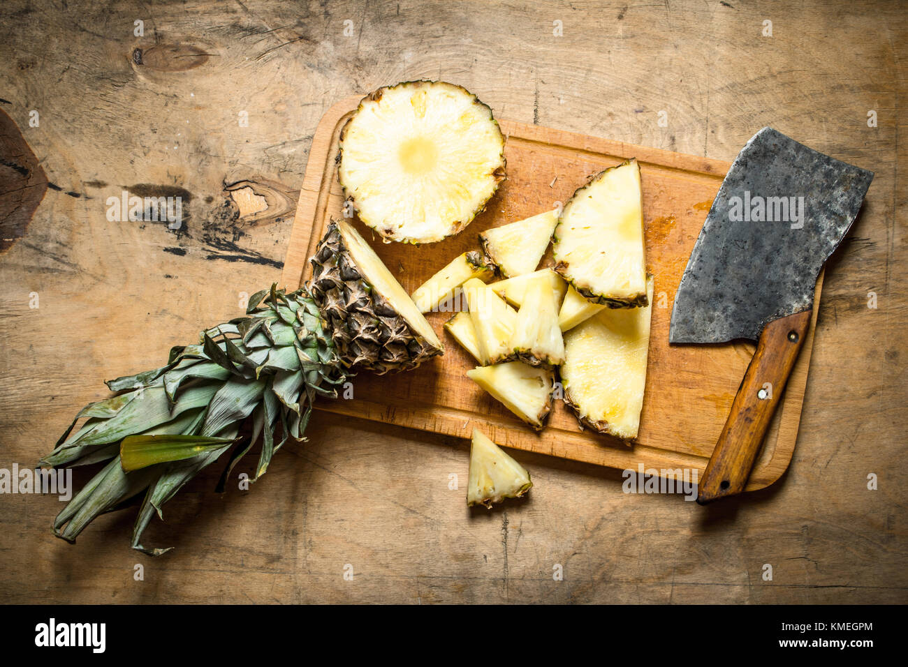 The pineapple on the Board with an axe. On a wooden table Stock Photo ...