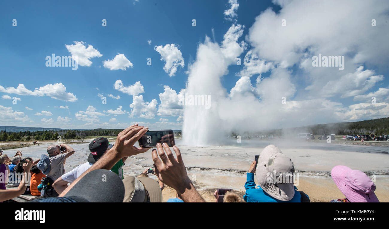 Tourists watching erupting Great Fountain Geyser, Yellowstone National ...