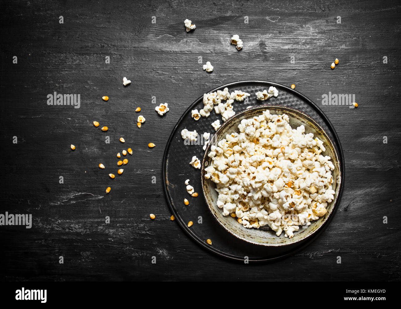 The popcorn in the plate. On the black wooden table Stock Photo - Alamy