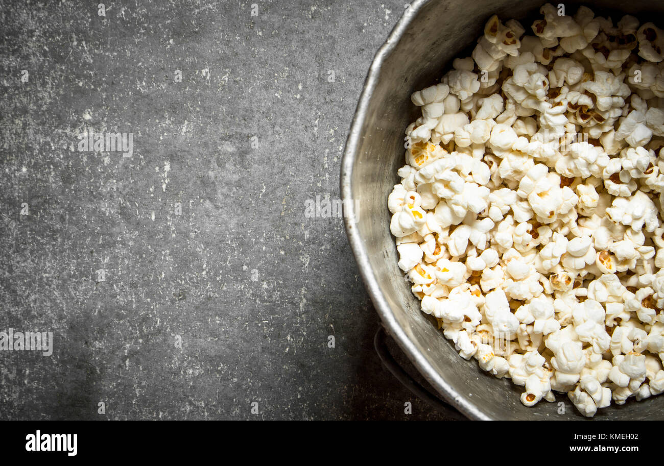 Popcorn in an old pot. On the Stone table Stock Photo - Alamy