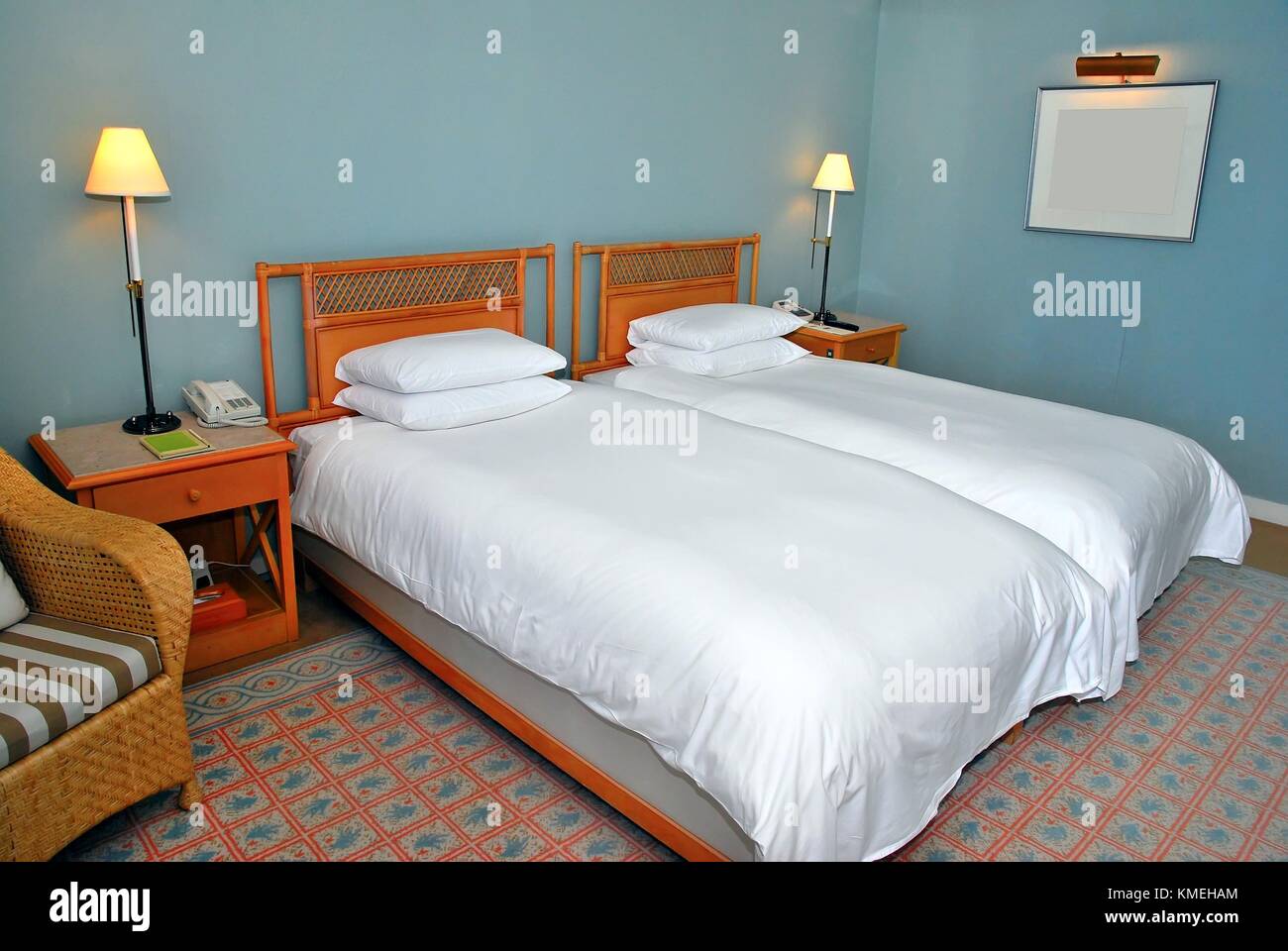 Twin beds with table lamps lighted up in a high class hotel room ...
