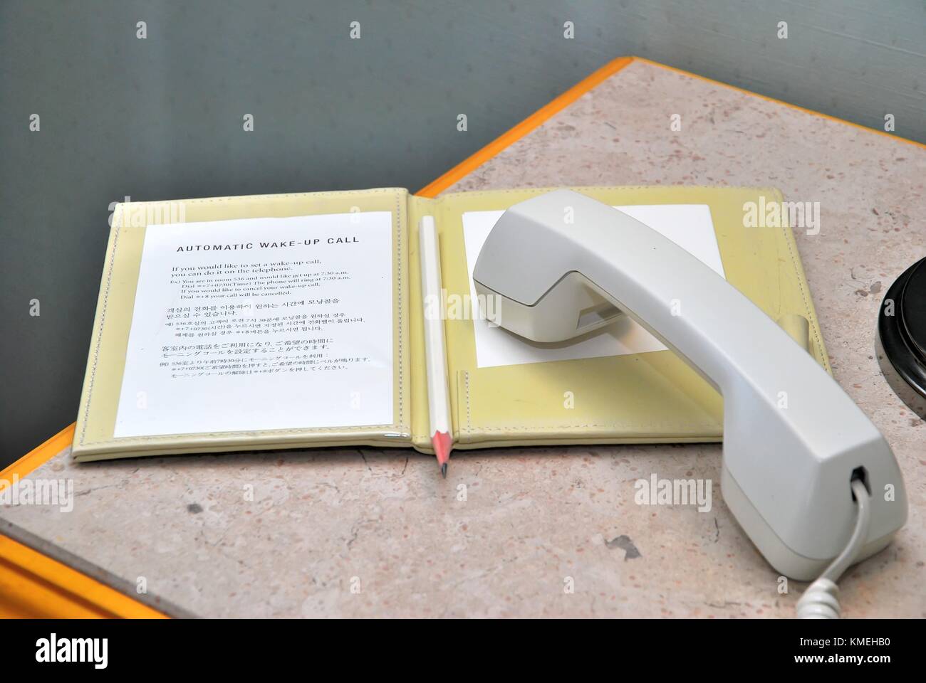 Phone receiver on top of memo pad in a hotel room. Symbolizes the hotel ...