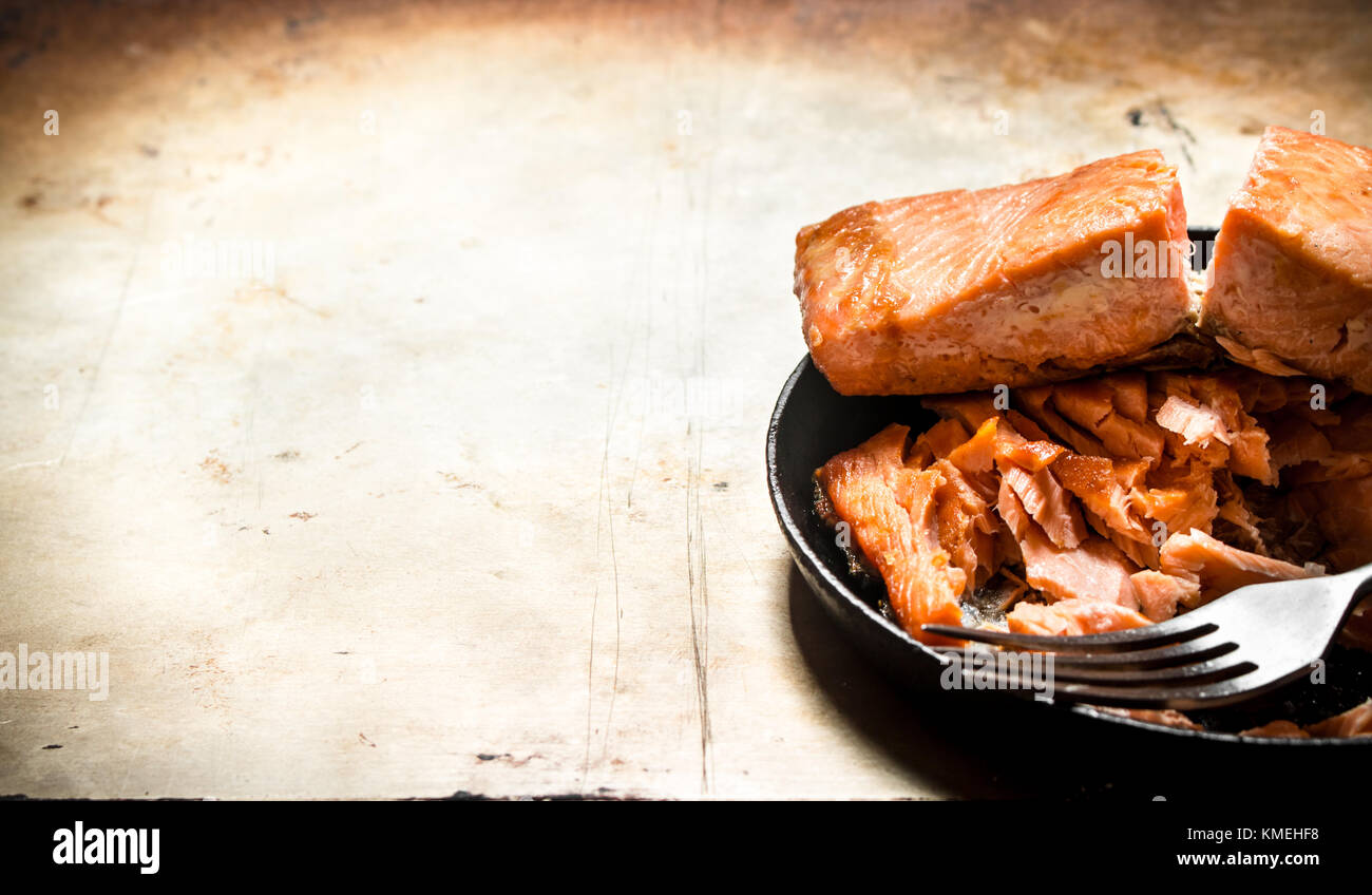Fried trout at the plate with a fork. On an old rustic background Stock ...