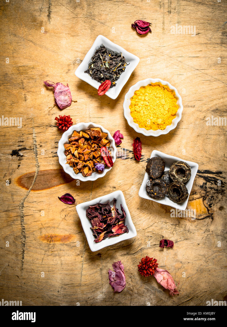 Different types of dried tea in the cups . On wooden background Stock ...