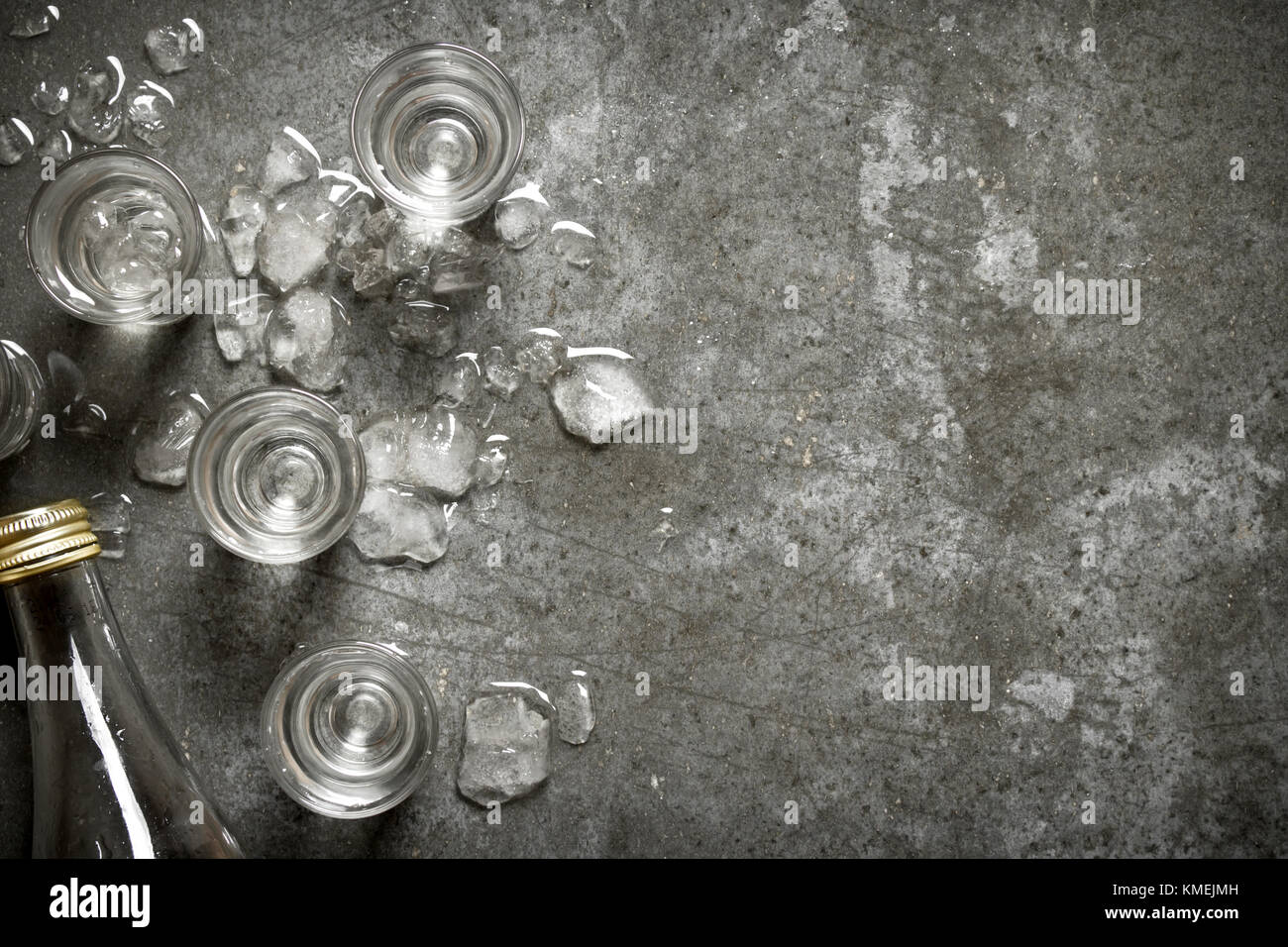 bottle of vodka with glasses and ice. On the stone table Stock Photo ...