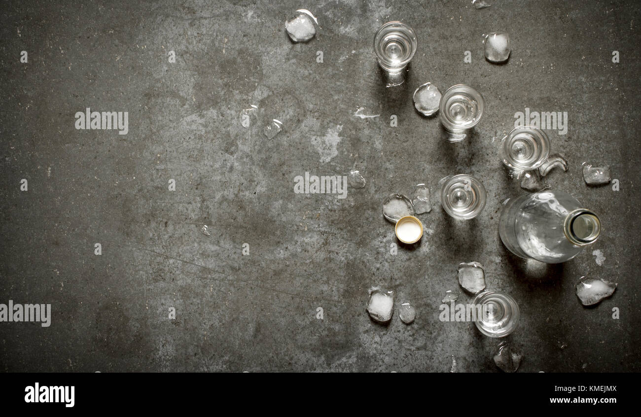 bottle of vodka with glasses and ice. On the stone table Stock Photo ...