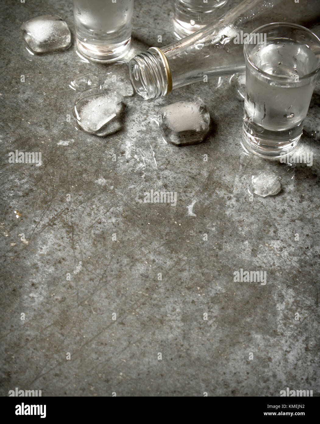 bottle of vodka with glasses and ice. On the stone table Stock Photo ...