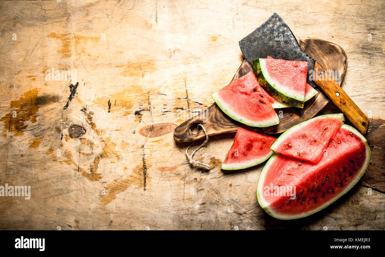 Sliced watermelon with an axe. On wooden background Stock Photo - Alamy