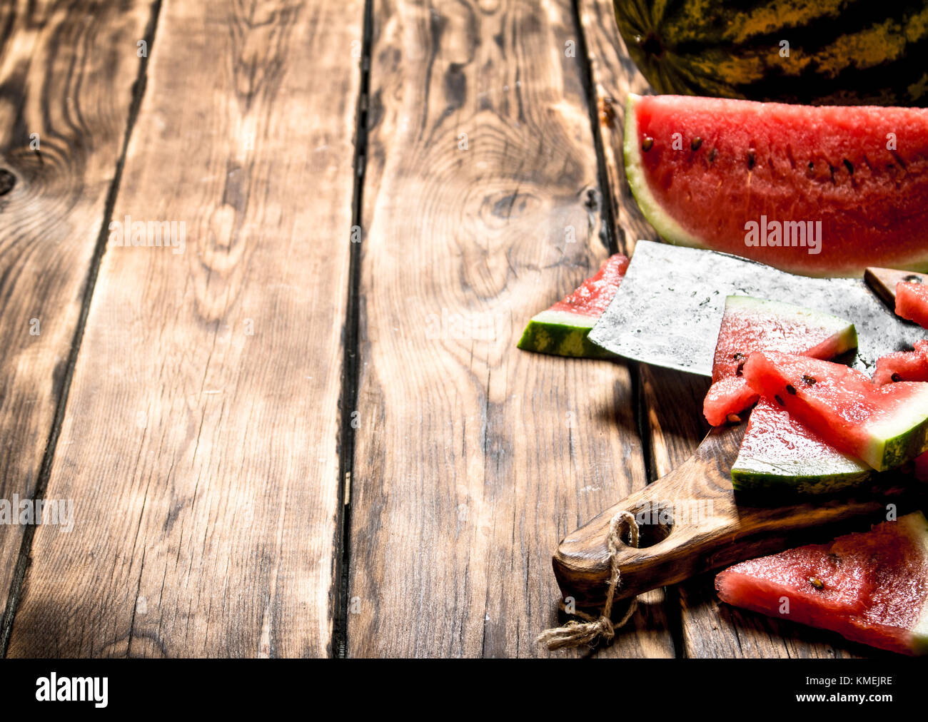 Sliced watermelon with an axe. On wooden background Stock Photo - Alamy