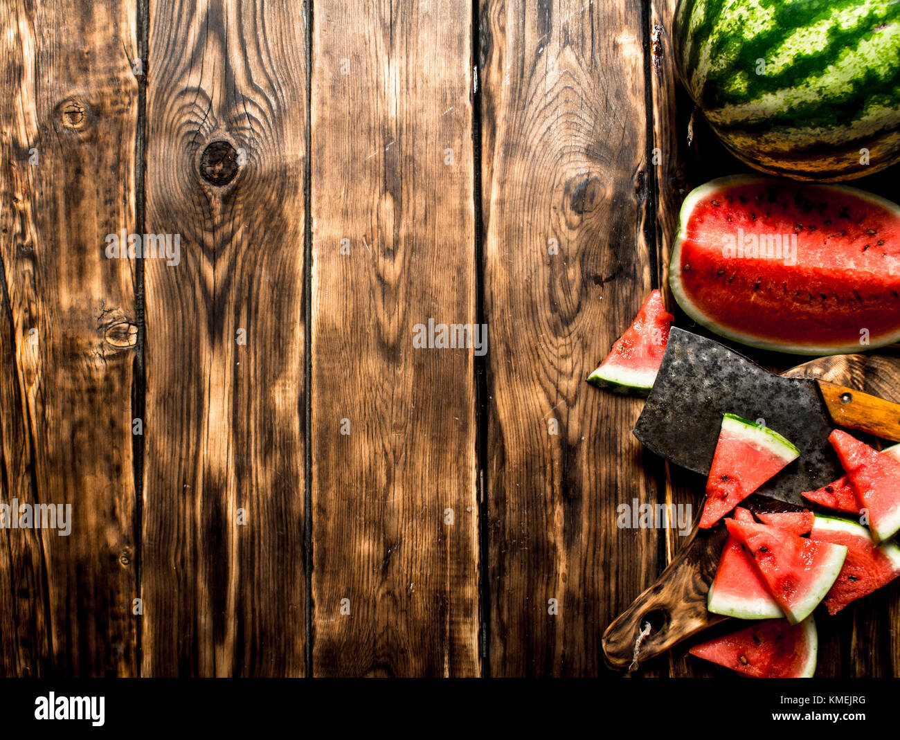 Sliced watermelon with an axe. On wooden background Stock Photo - Alamy