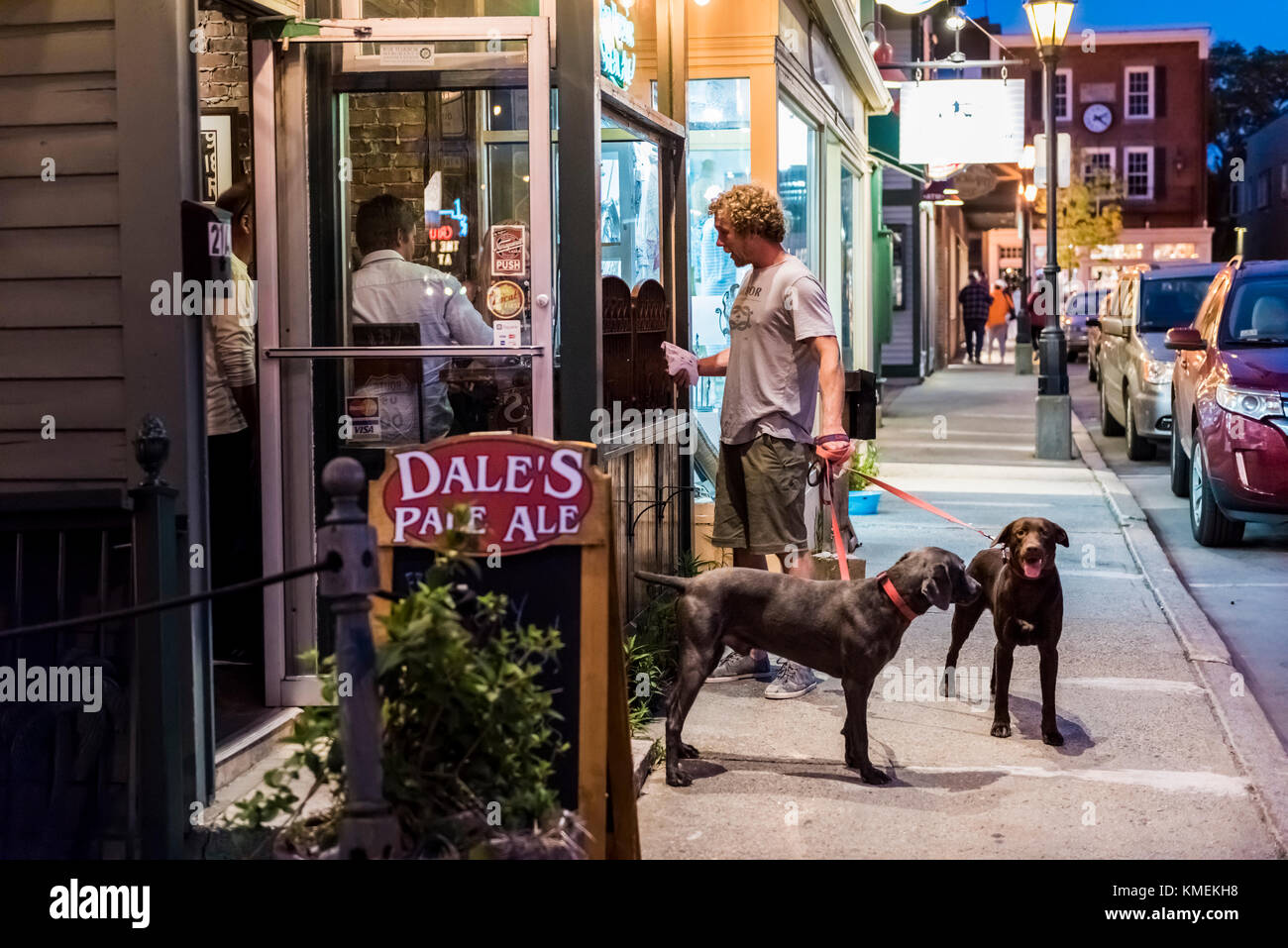Bar Harbor, USA - June 8, 2017: Person with dogs walking on sidewalk ...
