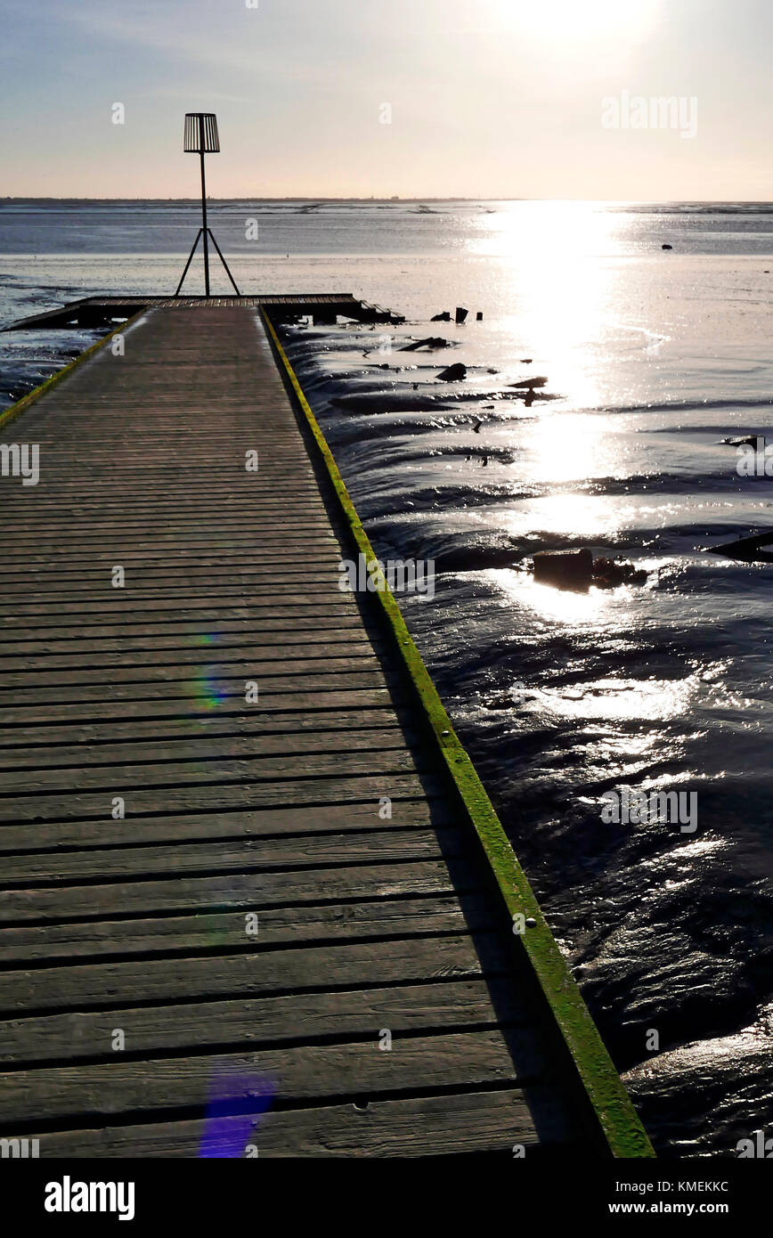 End of jetty into river estuary against low sun in winter Stock Photo ...