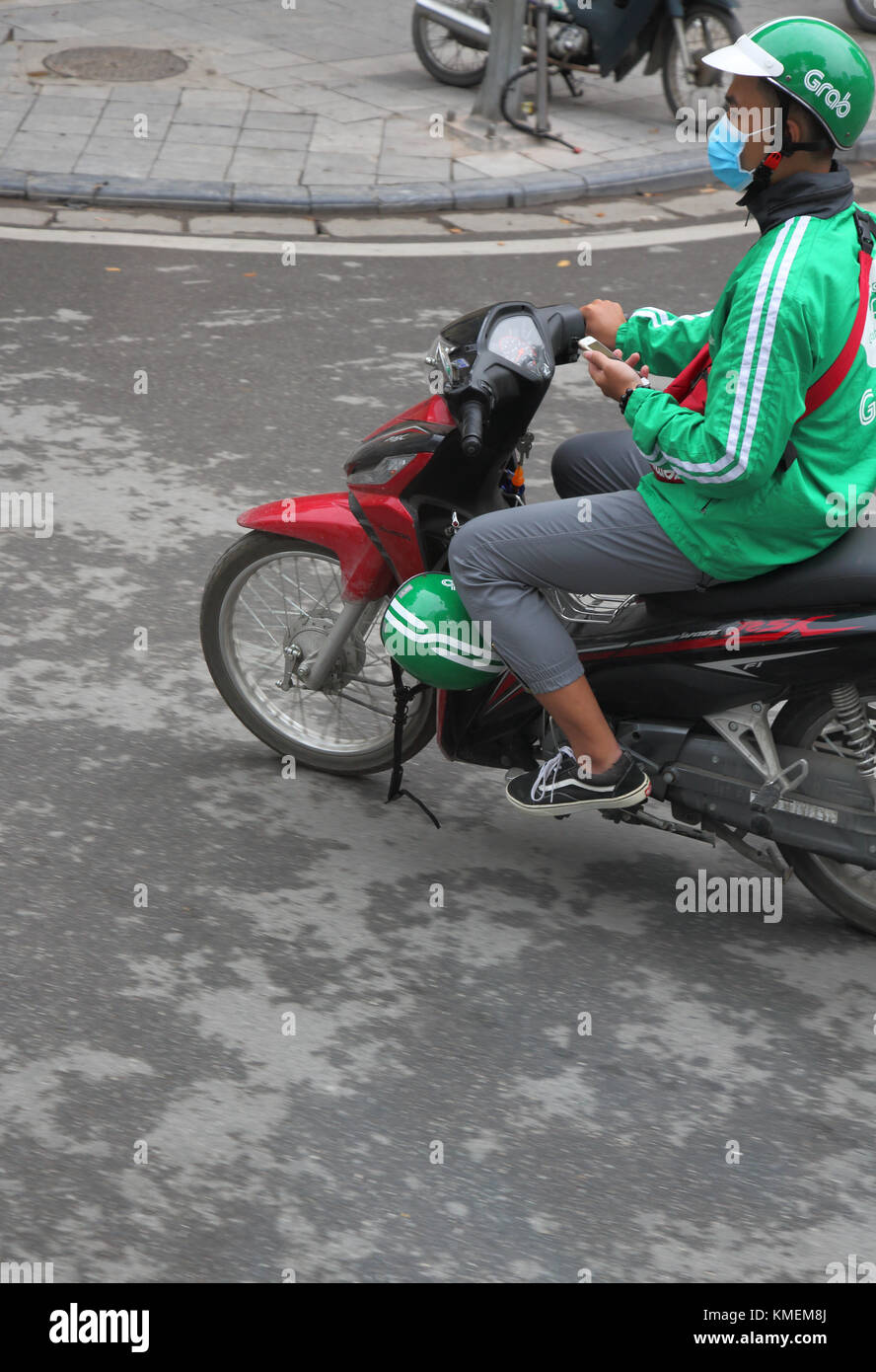 texting while riding a motorbike in hanoi vietnam Stock Photo - Alamy