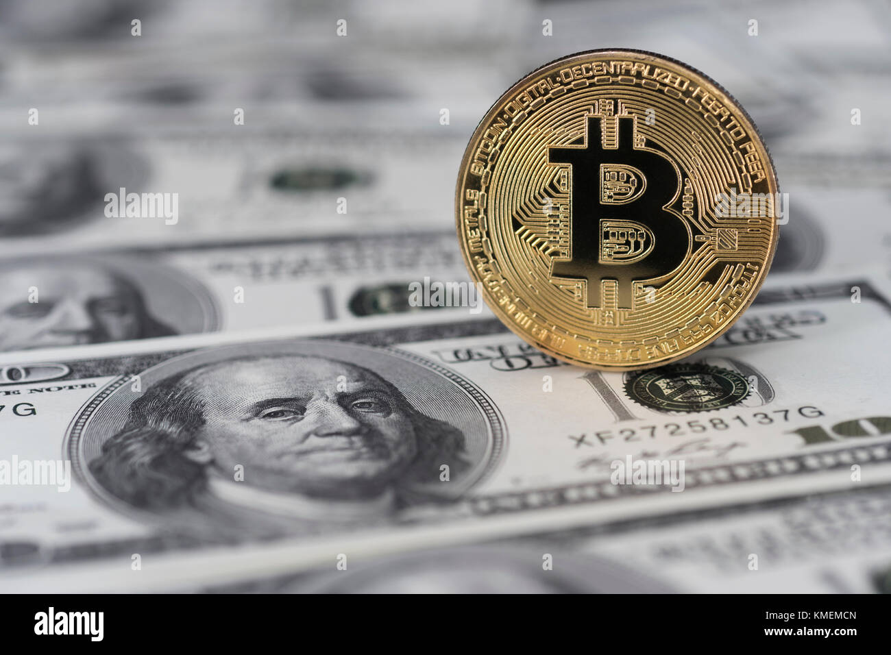 Gold-colored Bitcoin cryptocurrency with US $100 Franklin bills ...