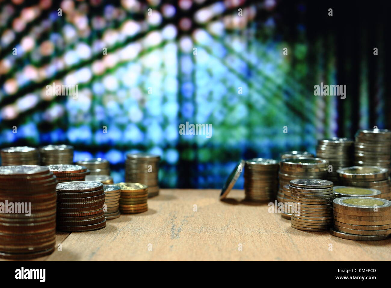 vintage digital economy coin pile stacked in to columns on wooden board ...