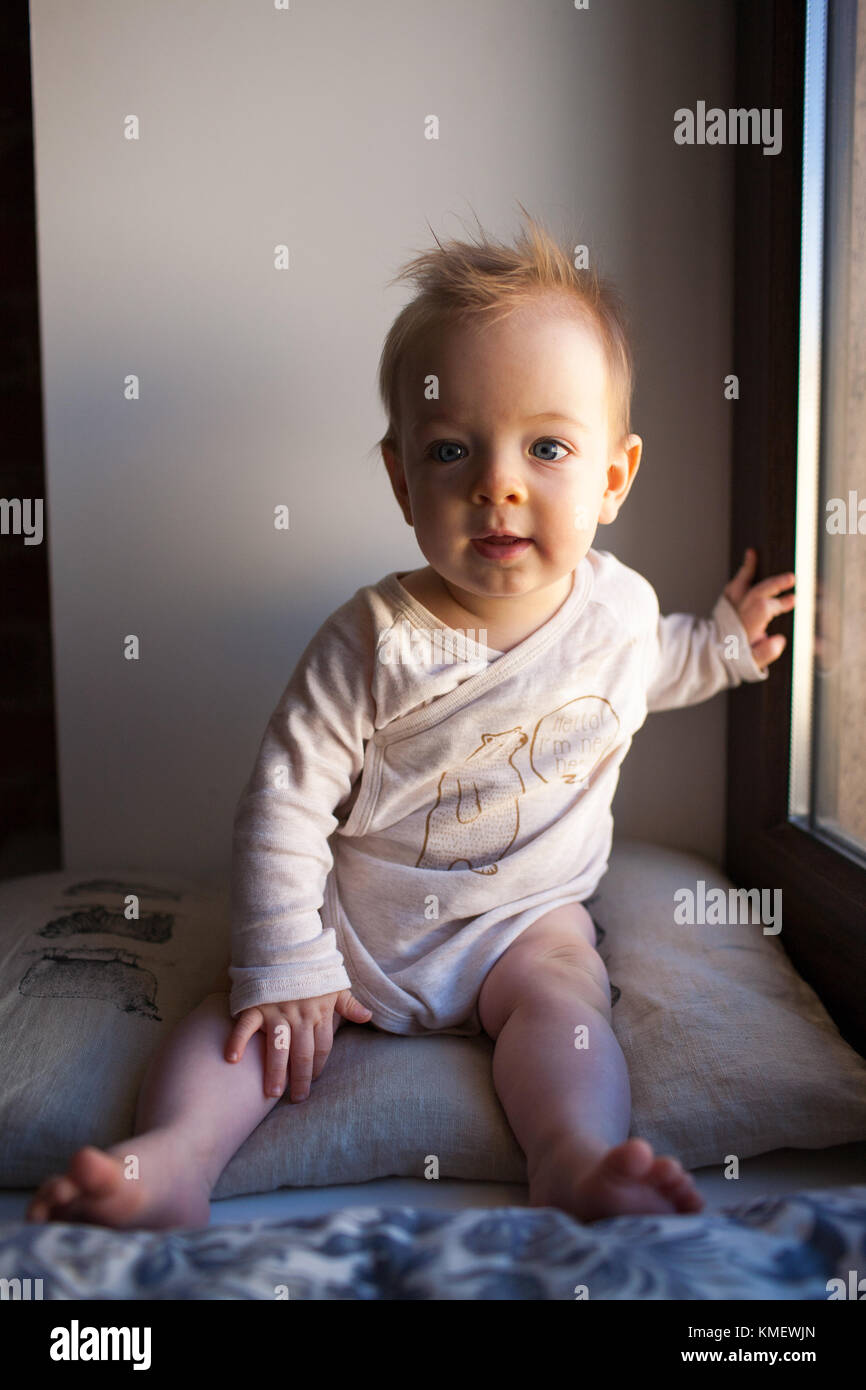 Portrait of a little boy who is sitting in the window and smiling ...