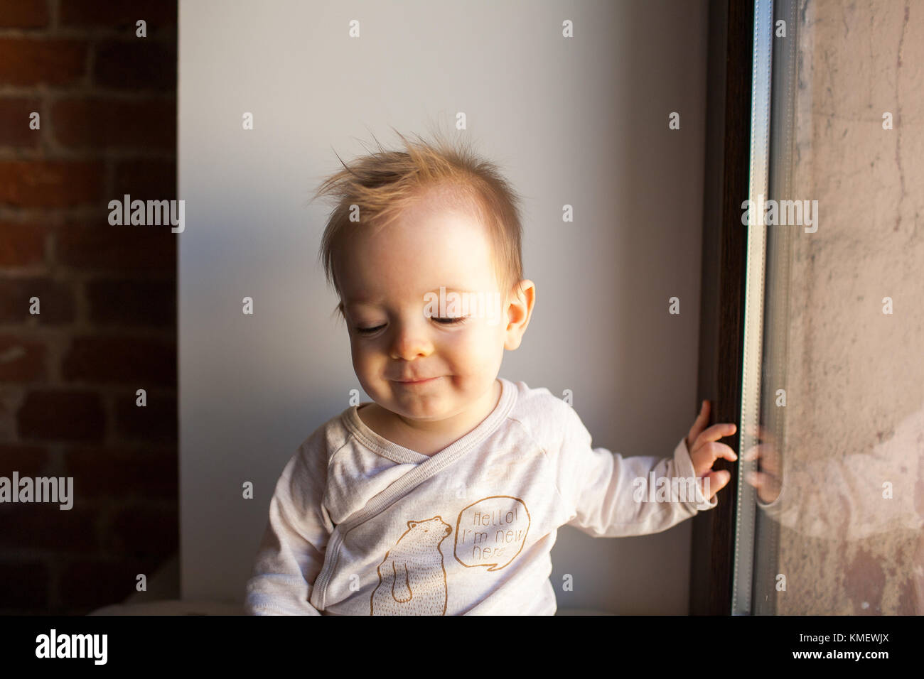 Portrait of a little boy who is sitting in the window and smiling ...