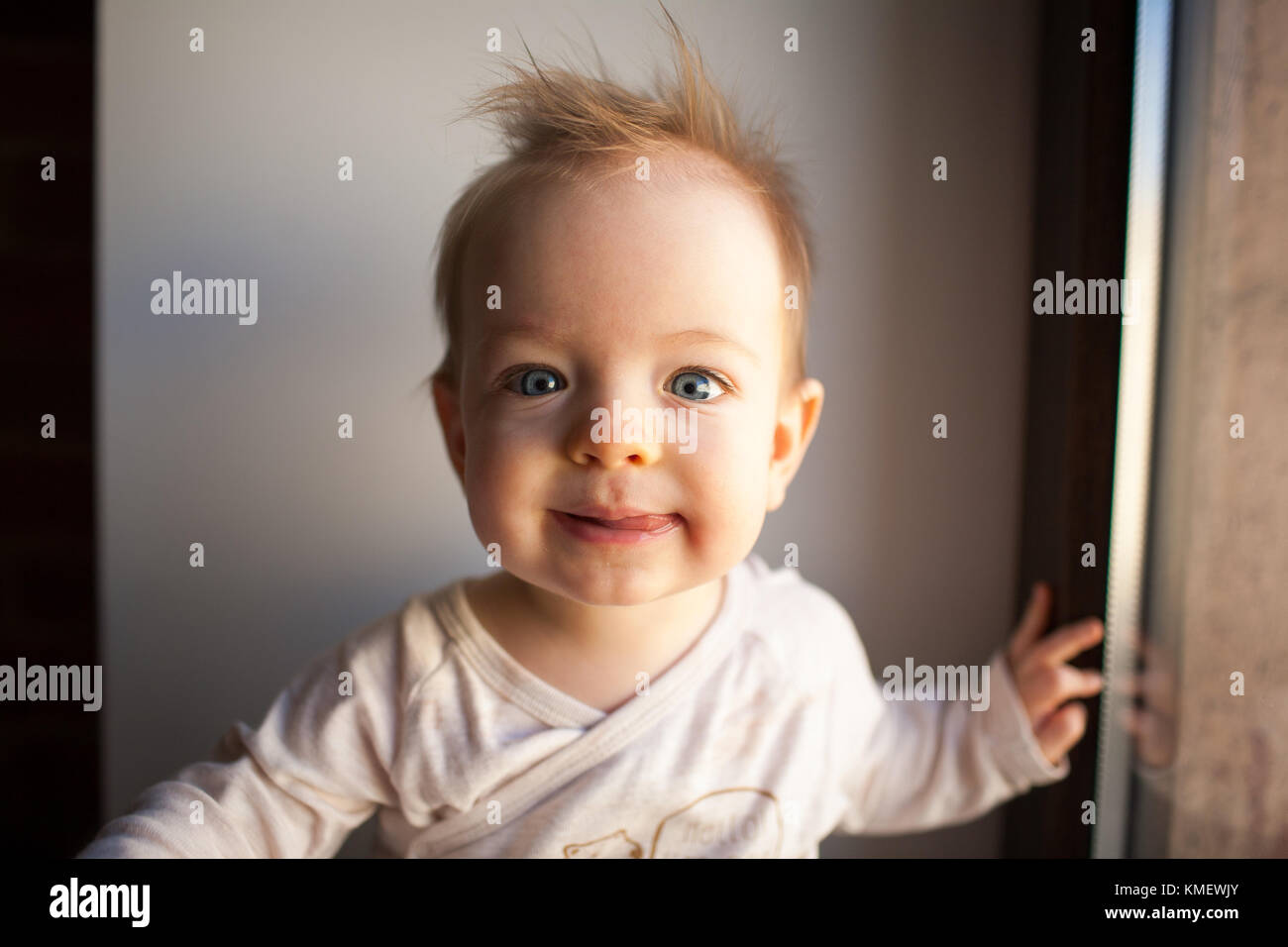 Portrait of a little boy who is sitting in the window and smiling ...