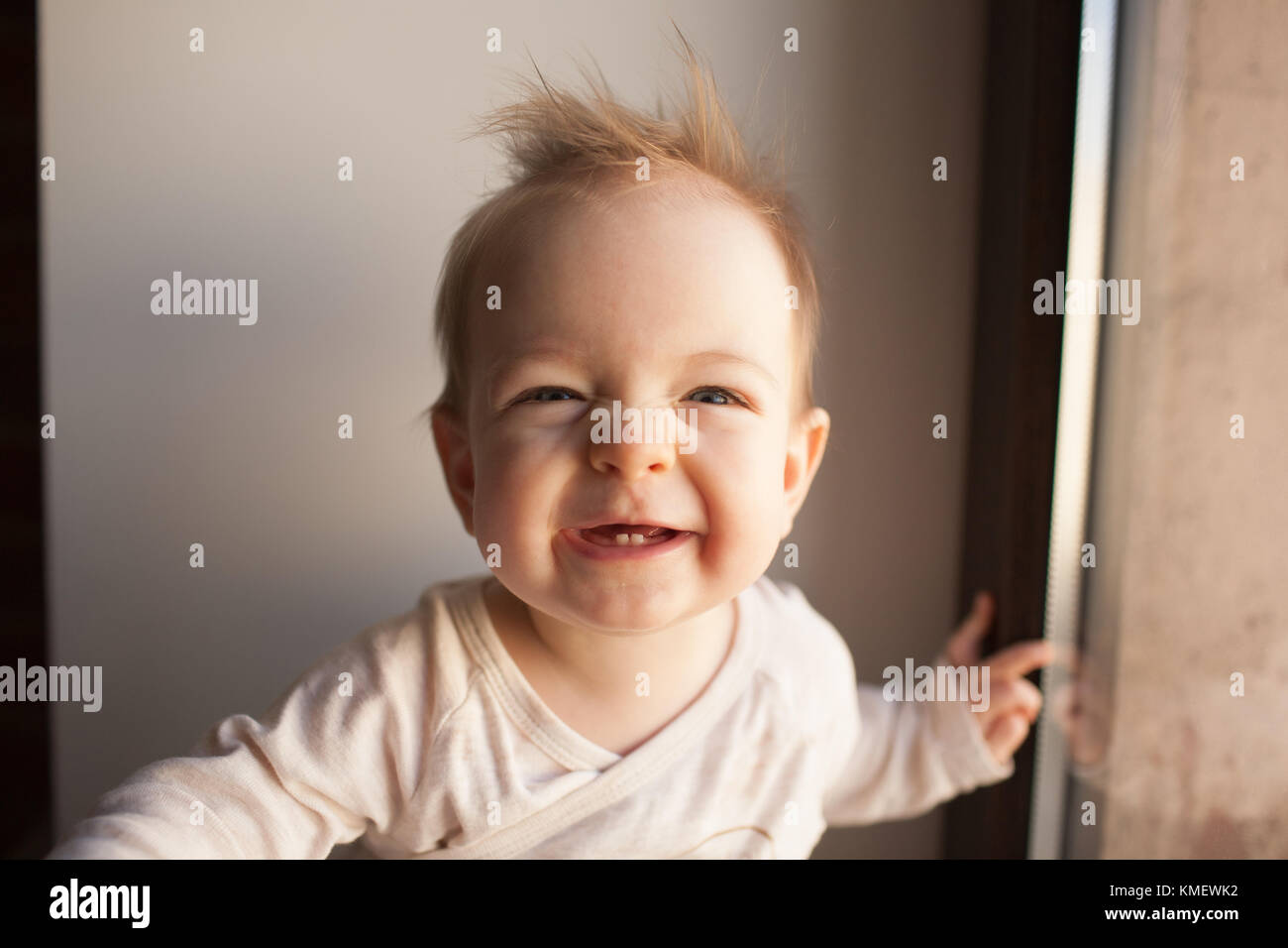 Portrait of a little boy who is sitting in the window and smiling ...