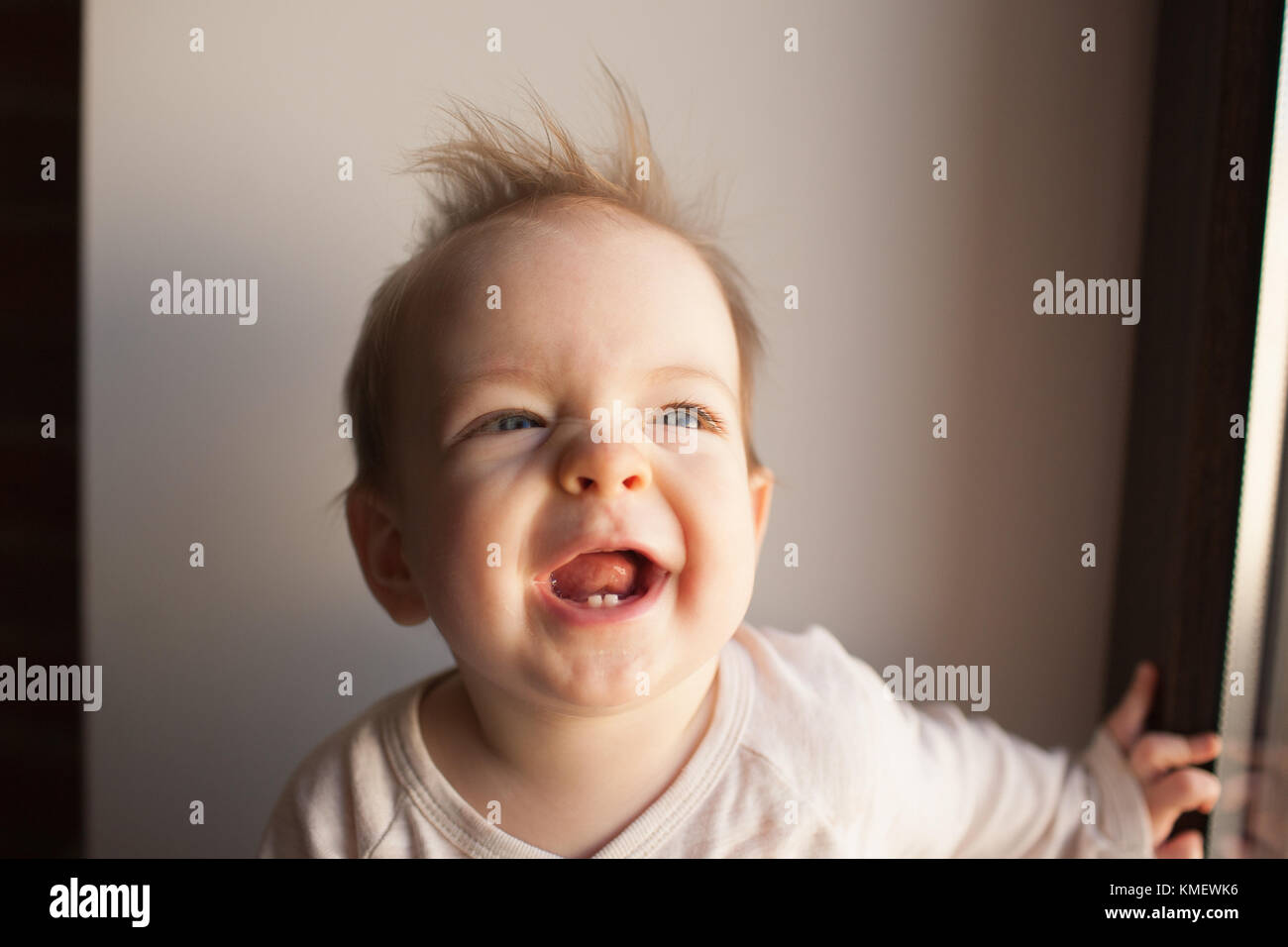 Portrait of a little boy who is sitting in the window and smiling ...