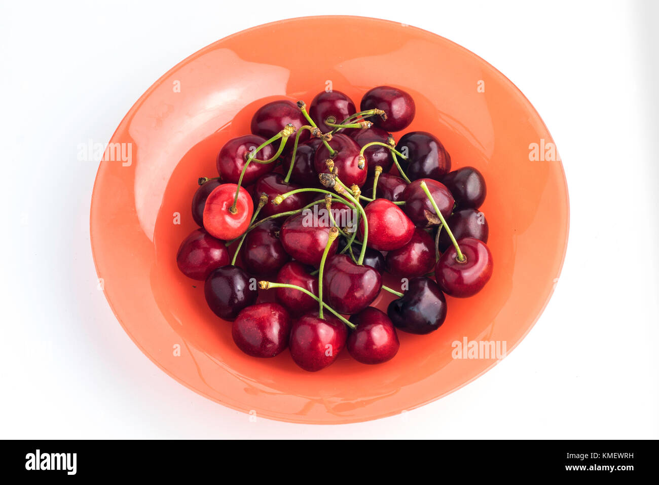 Orange plate full of sweet red cherries on a white background Stock ...