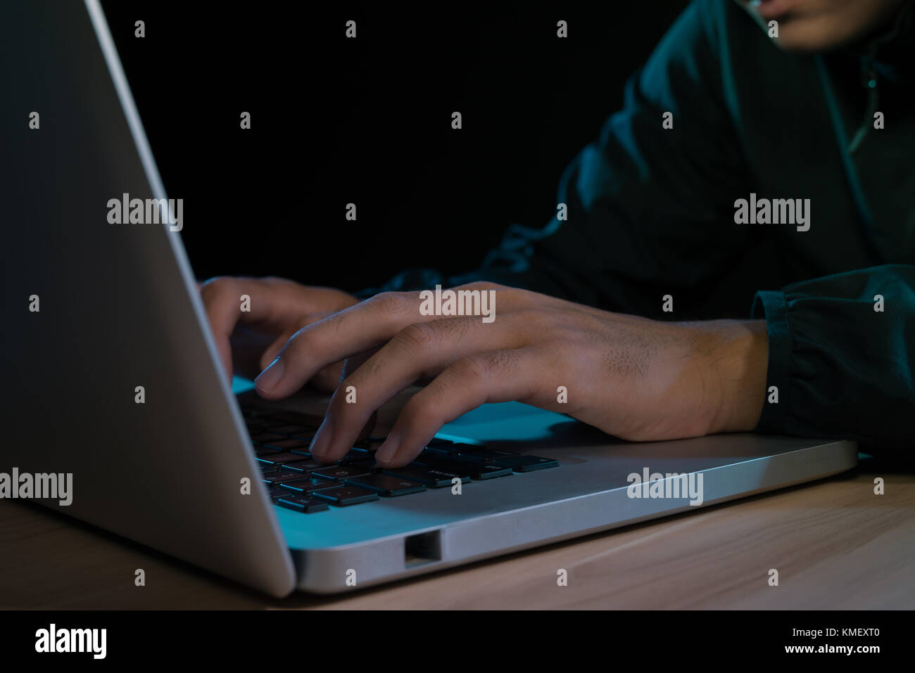 Asian hacker hacking computer network with laptop in dark. Cyber ...