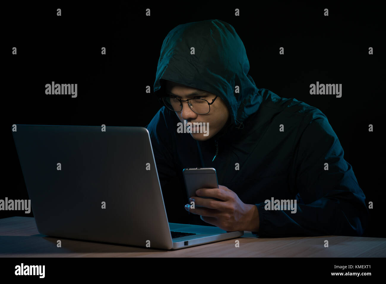Asian hacker hacking computer network with laptop in dark. Cyber ...