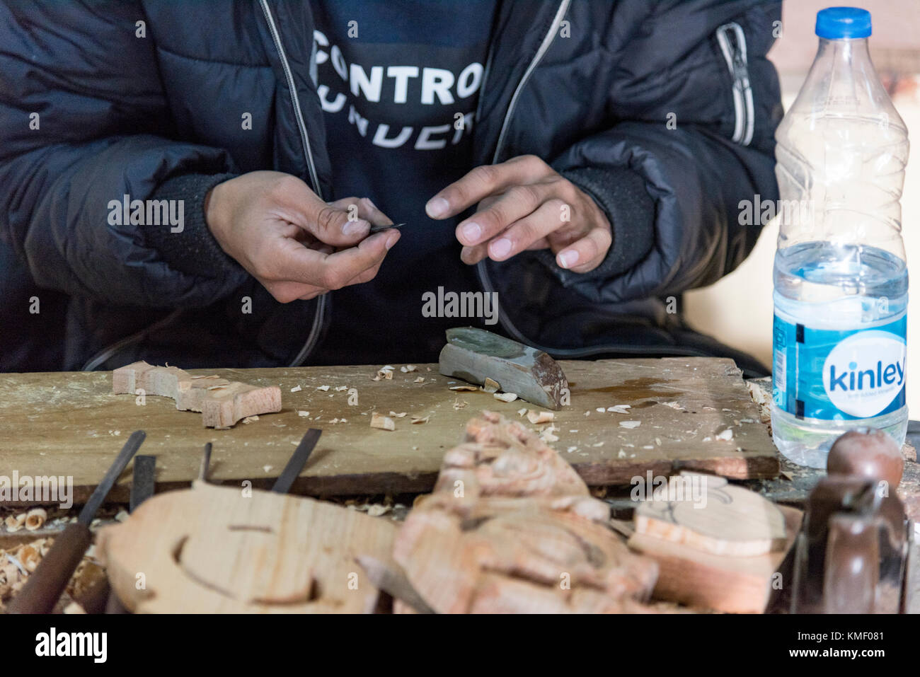 A man making art and craft pieces using chisel on wood Stock Photo - Alamy