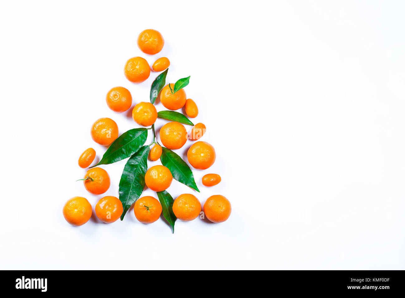 Christmas tree made from fresh mandarin with leaves on a white ...