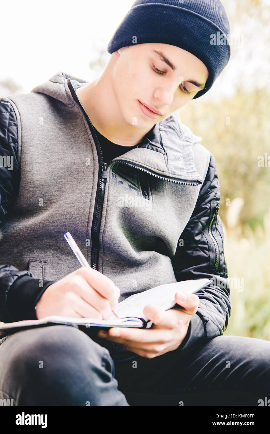 Millennial writing on a notepad Stock Photo - Alamy