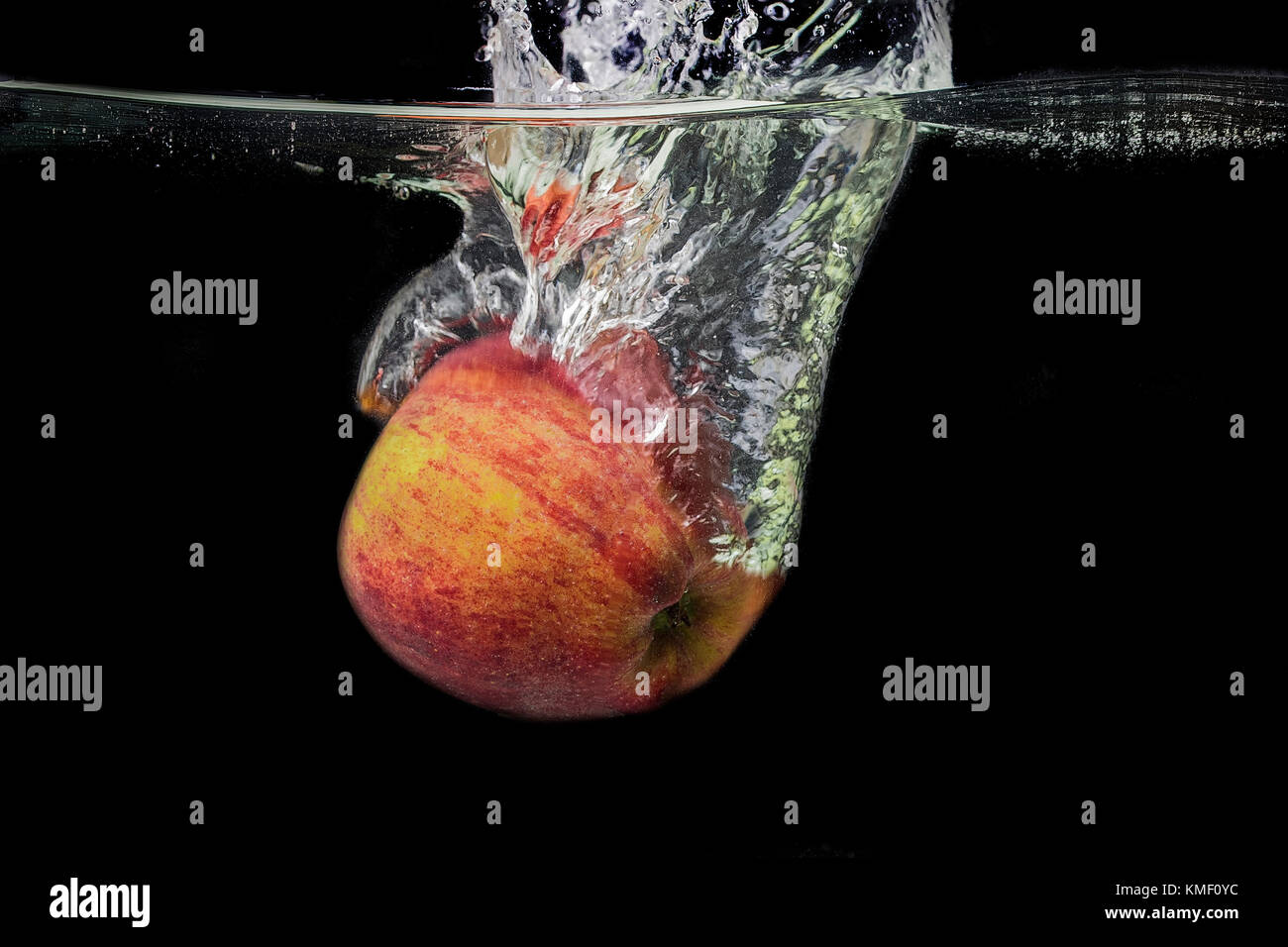Apple falls into the water and makes a splash Stock Photo - Alamy